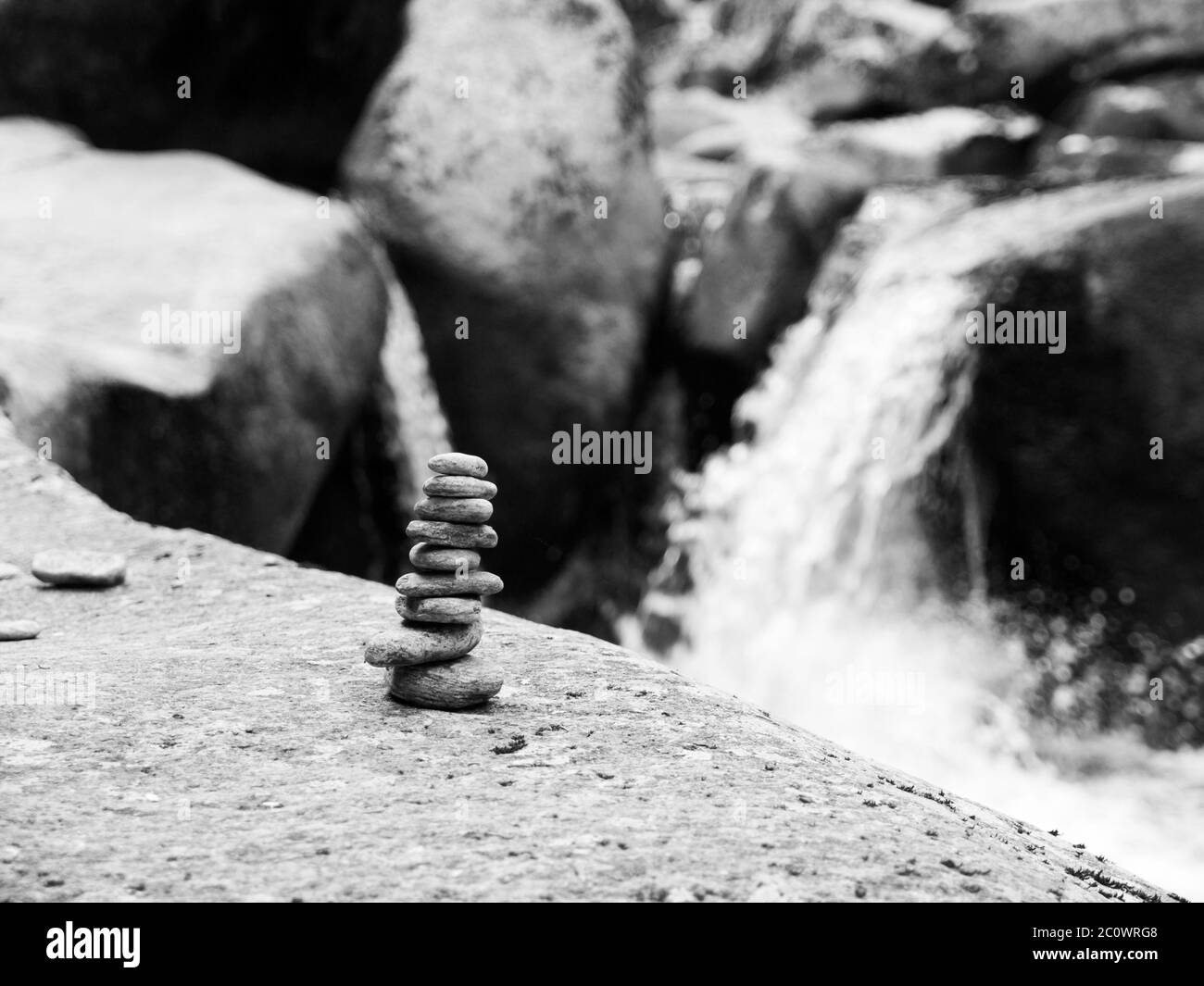 Balanced pebble stone pyramid with unfocused river waterfall on ...