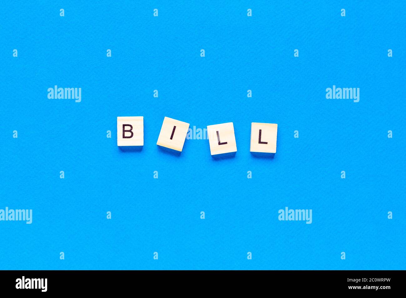 bill in wooden letters on a blue background, flat layout, top view ...