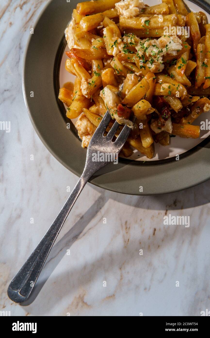 Canadian Poutine fries with gravy and cheese curd on marble kitchen ...