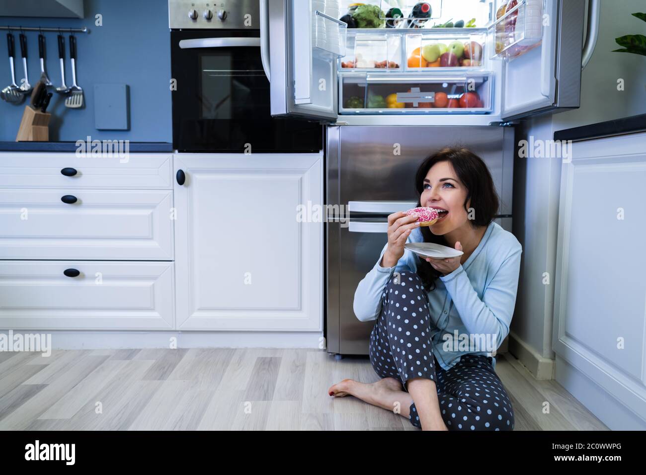 Open Night Sweet Indulgence. Woman Eating Near Refrigerator Stock Photo ...