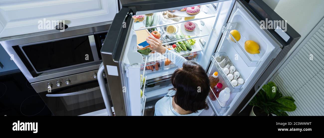 Hungry Woman At Night With Open Fridge Stock Photo - Alamy