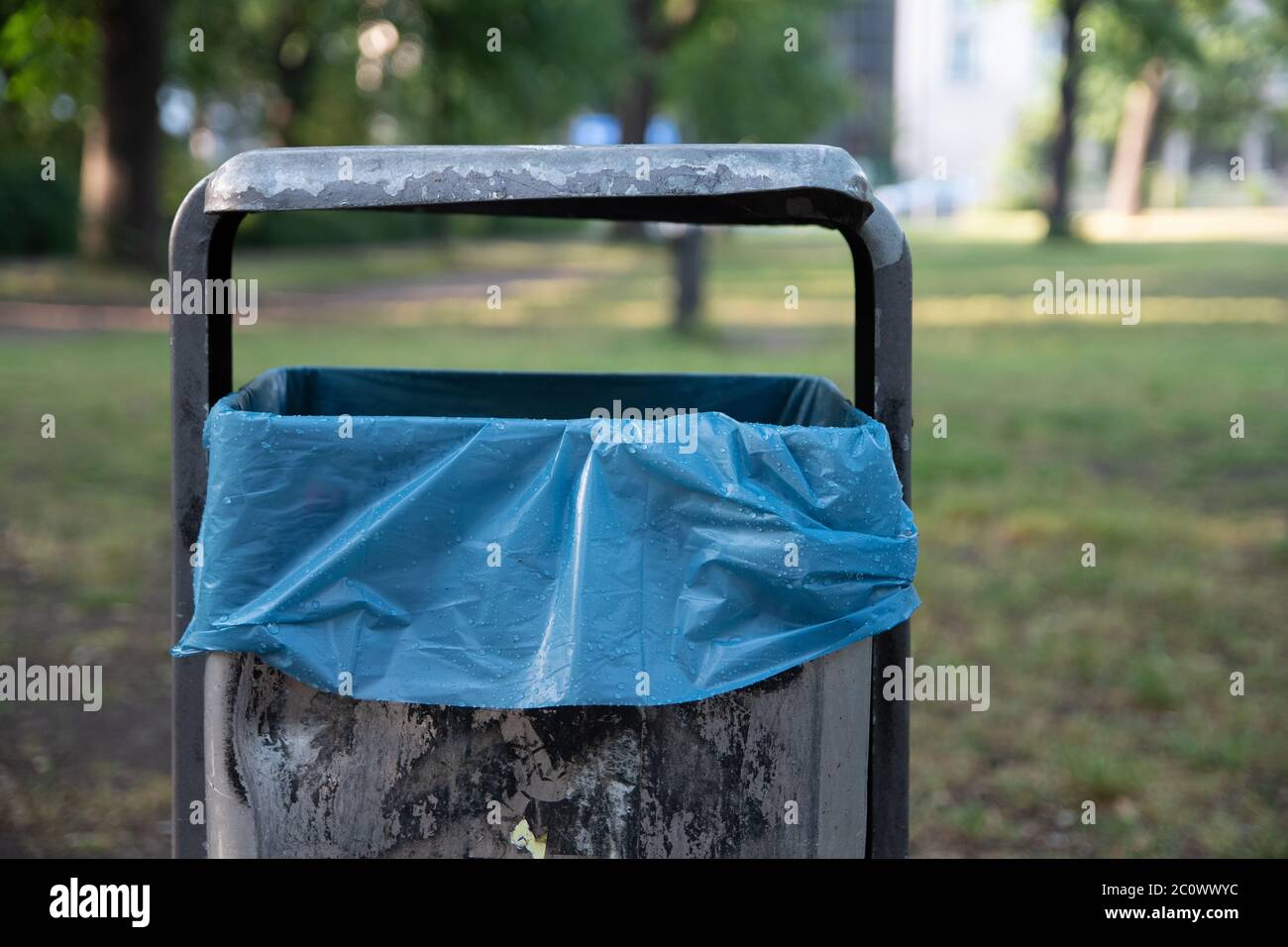 Empty, dirty and damaged trash bin in a park Stock Photo - Alamy