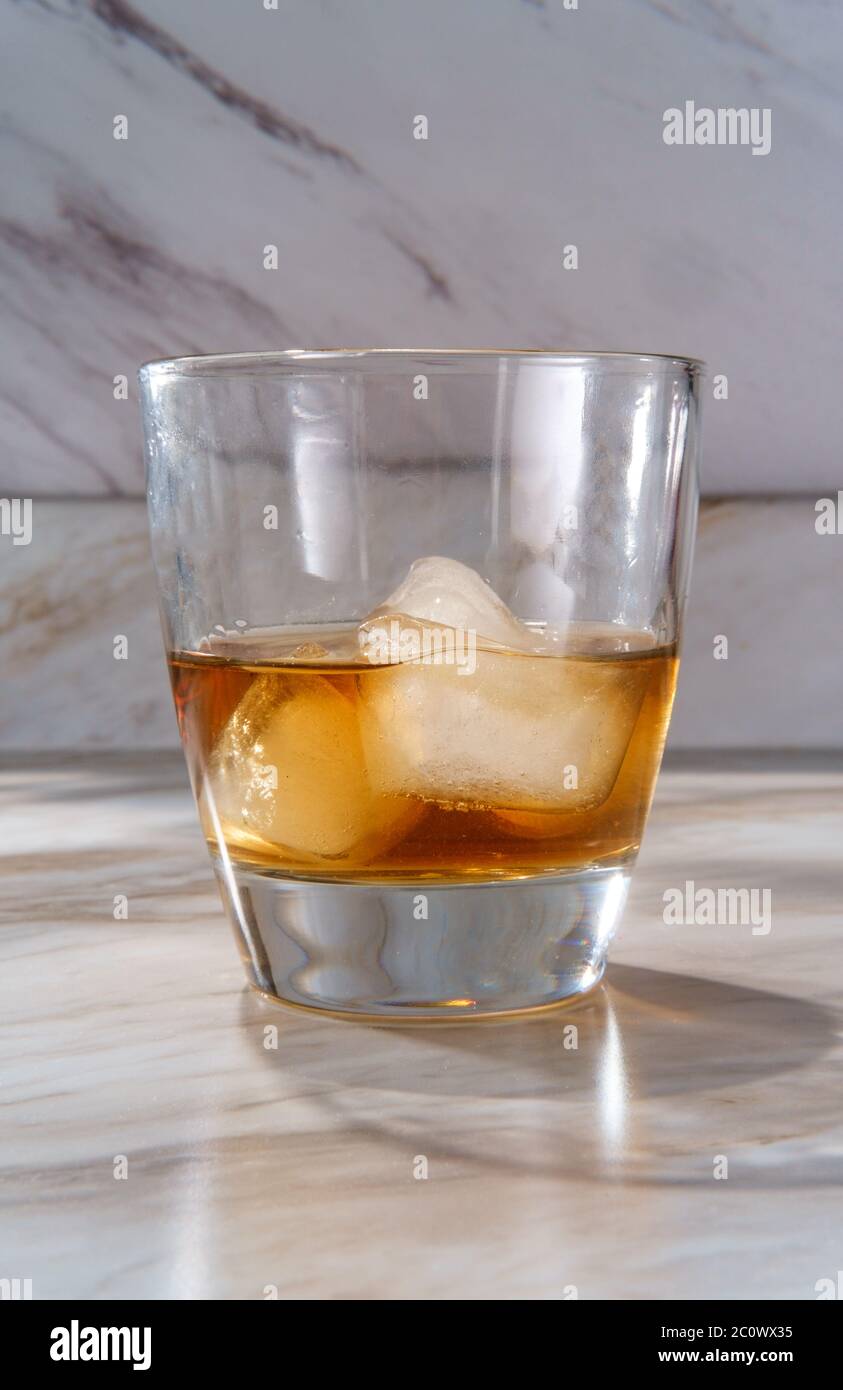 Whiskey with ice in rocks glass on marble kitchen counter Stock Photo ...