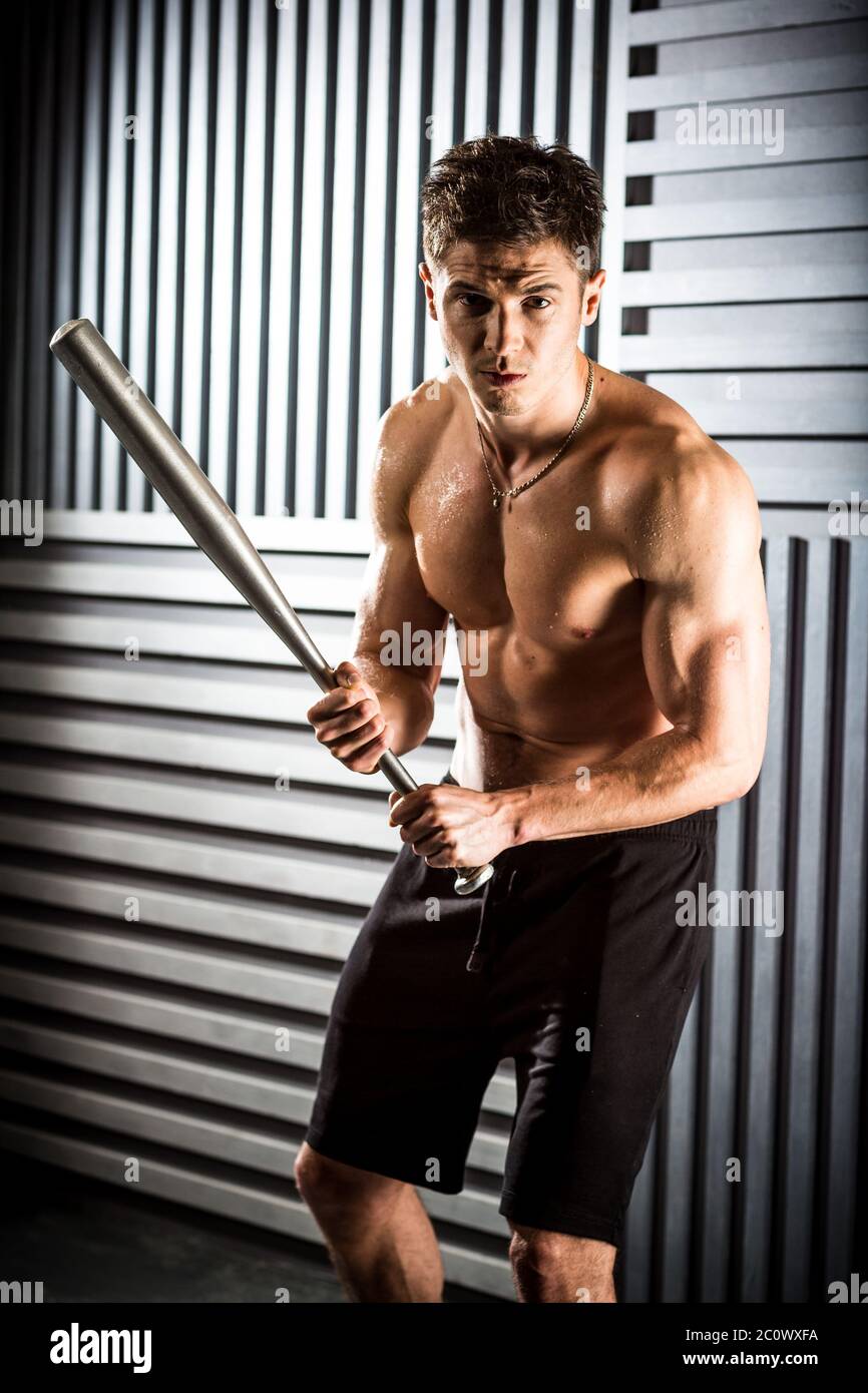 muscular man posing with a bat Stock Photo - Alamy
