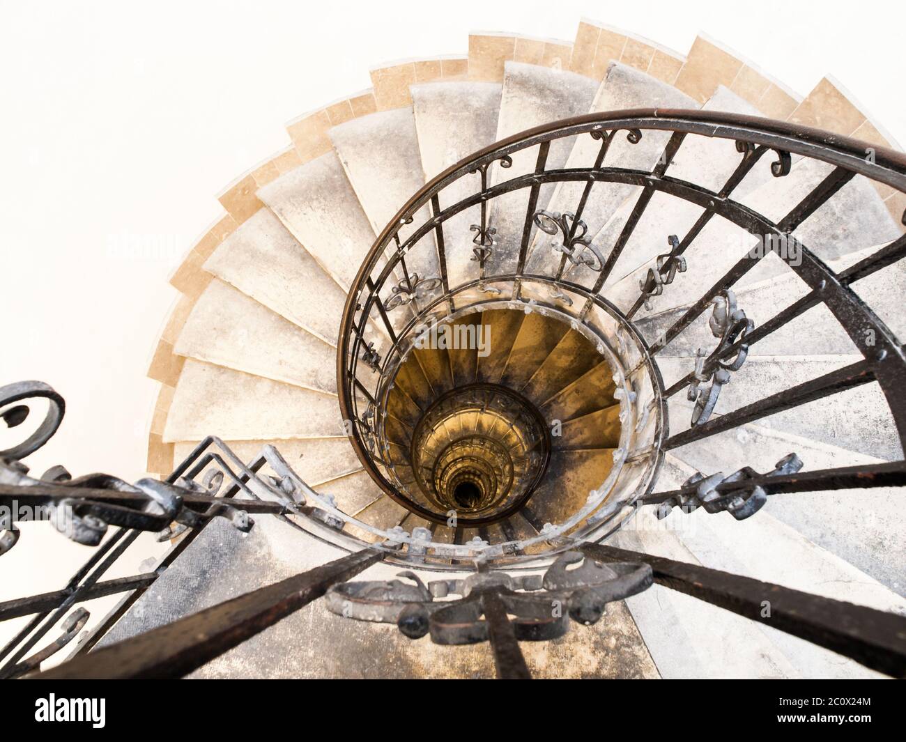 Upside view of indoor spiral winding staircase with black metal ...