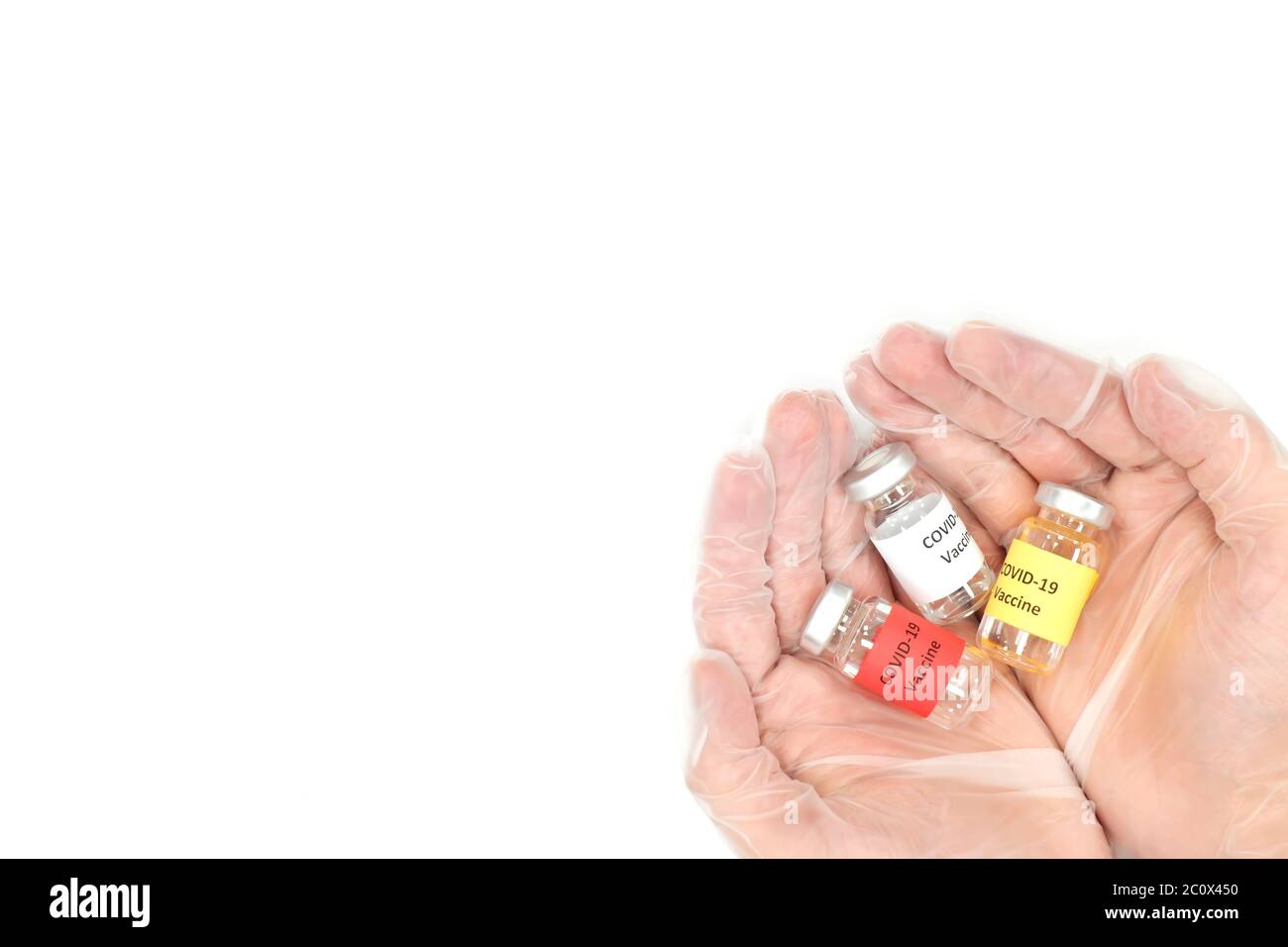 Cupped hands holding multiple covid-19 vaccine vials isolated in white background. Hope concept ...