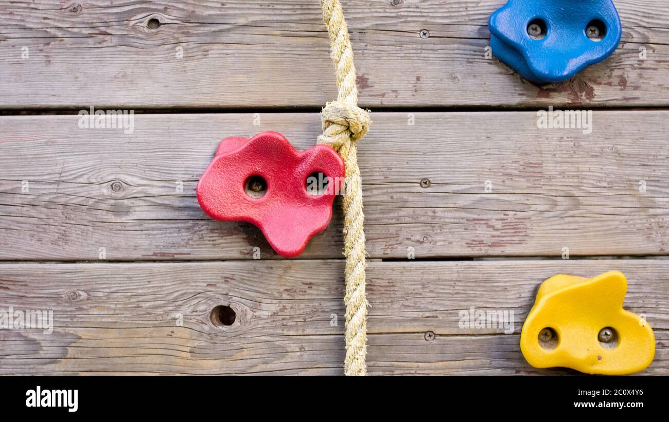 Wooden wall for climbing with plastic grip handles and ropes on ...