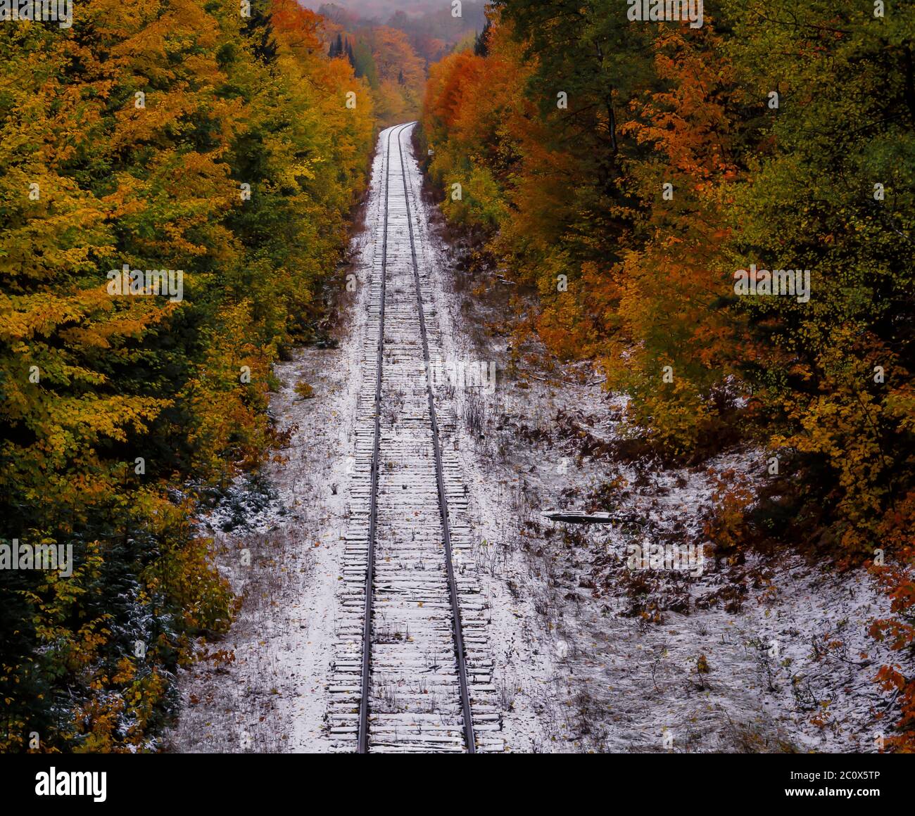 Autumn colors and fresh snowfall along railroad tracks in Michigan's ...