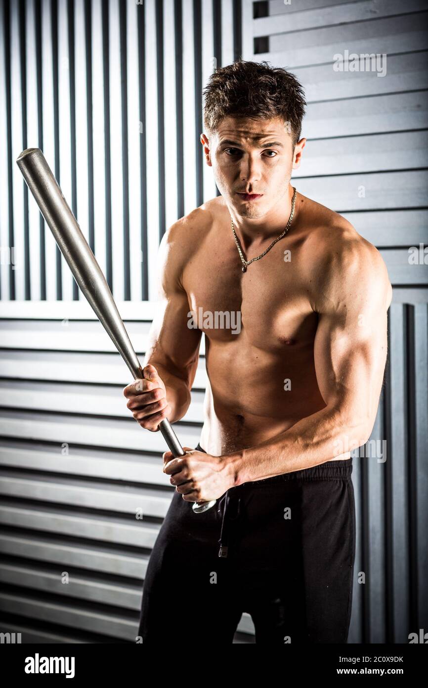 muscular man posing with a bat Stock Photo - Alamy