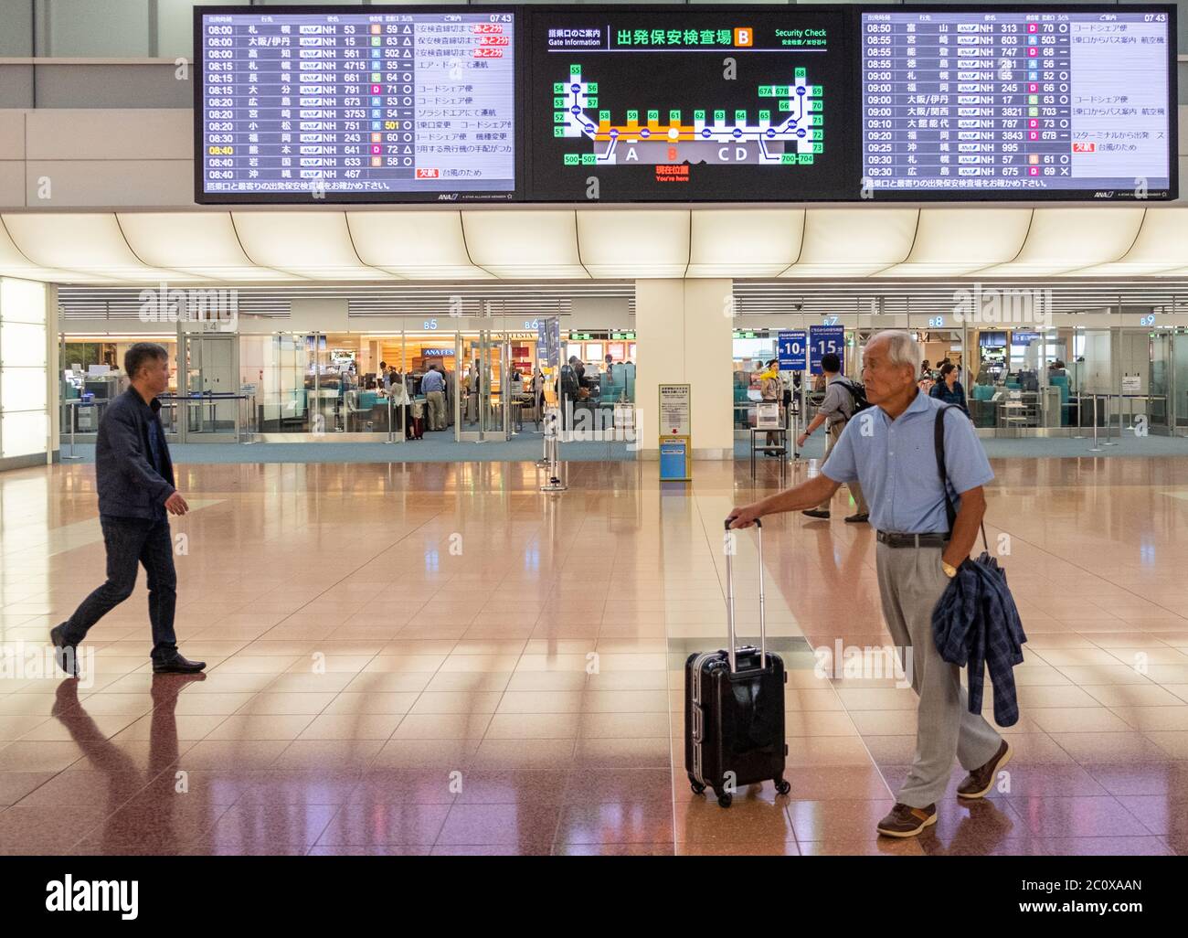 Passengers at the Haneda International Airport departure terminal ...
