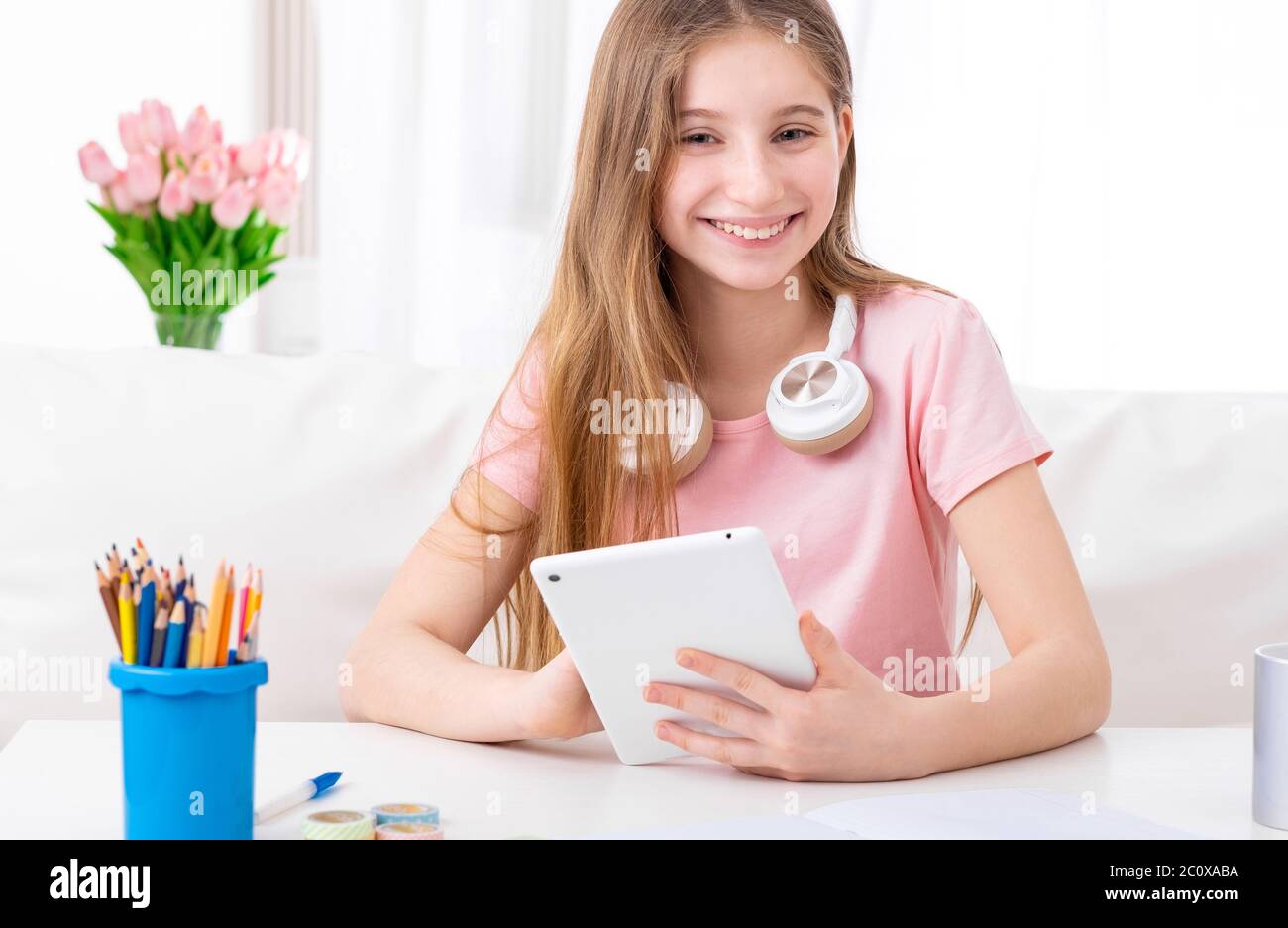 Girl is exploring social networks on her tablet at her working place ...
