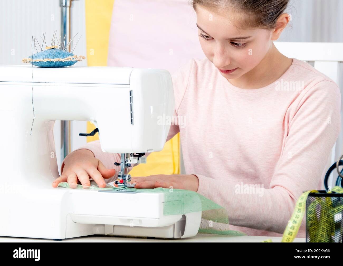 Little tailor girl is working with sewing machine carefully Stock Photo ...