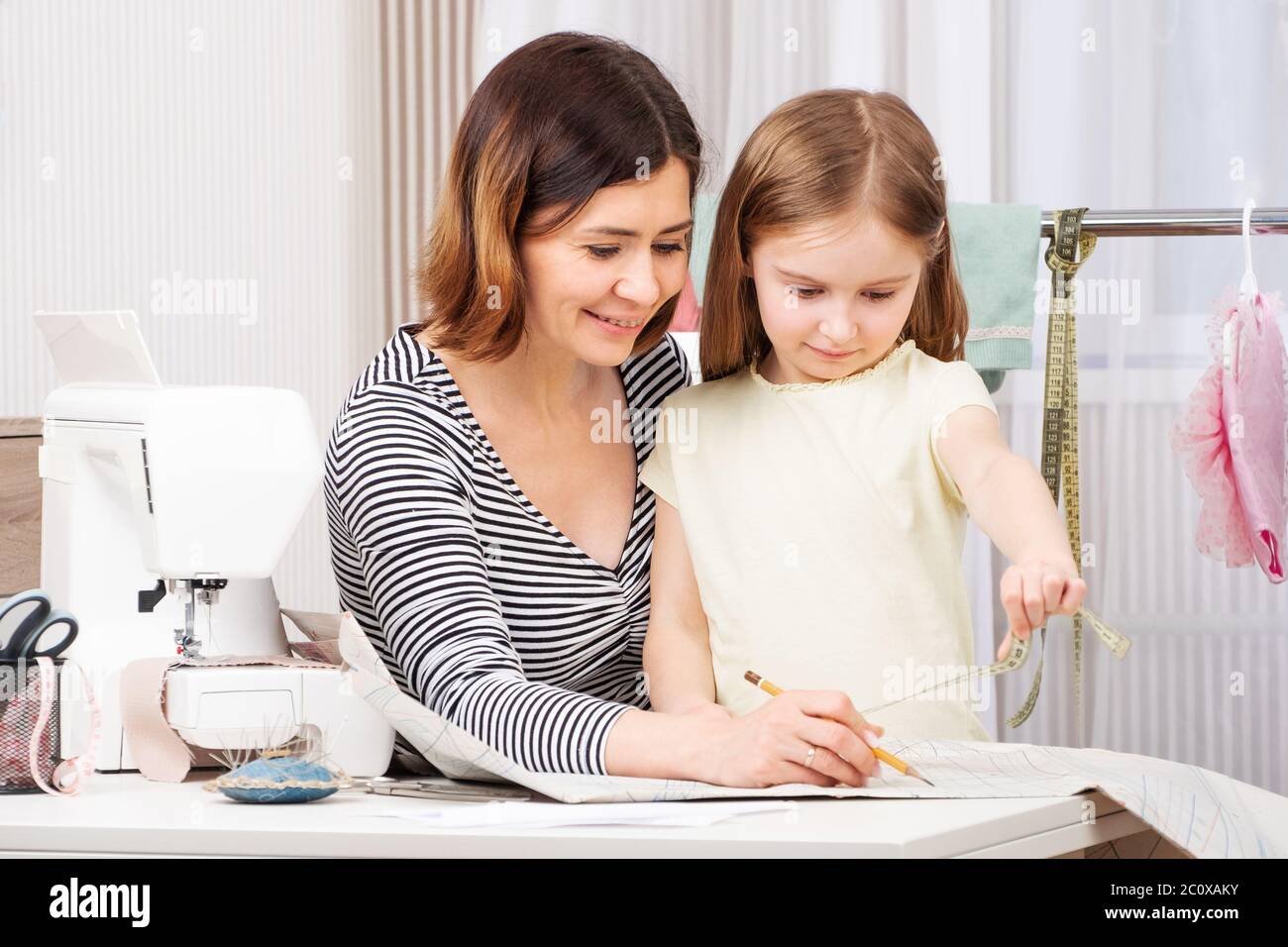 Master seamstress is teaching her pupil how to work with taken ...