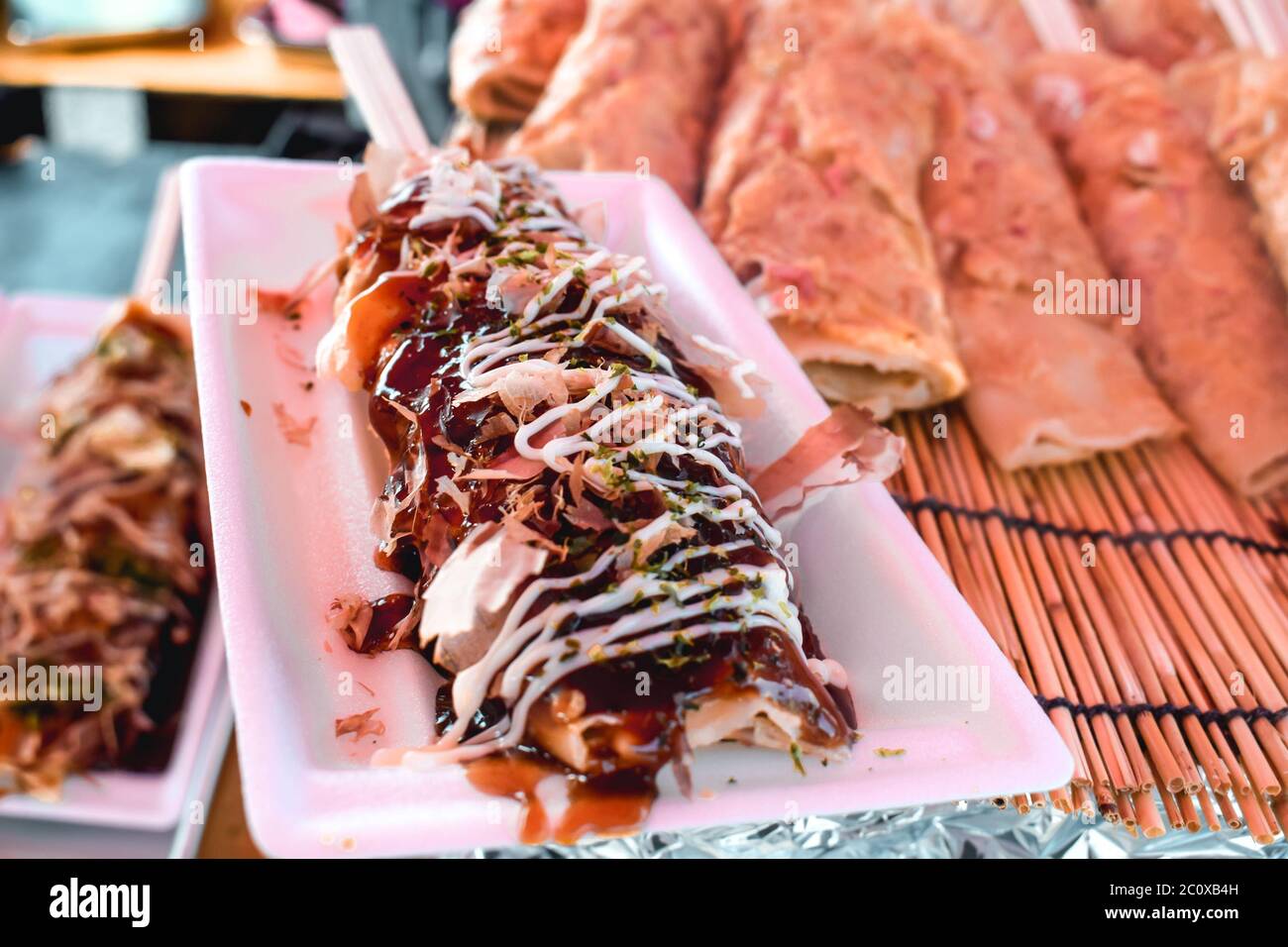 Hashimaki Japanese salty pancake with teriyaki sauce on a chopstick ...