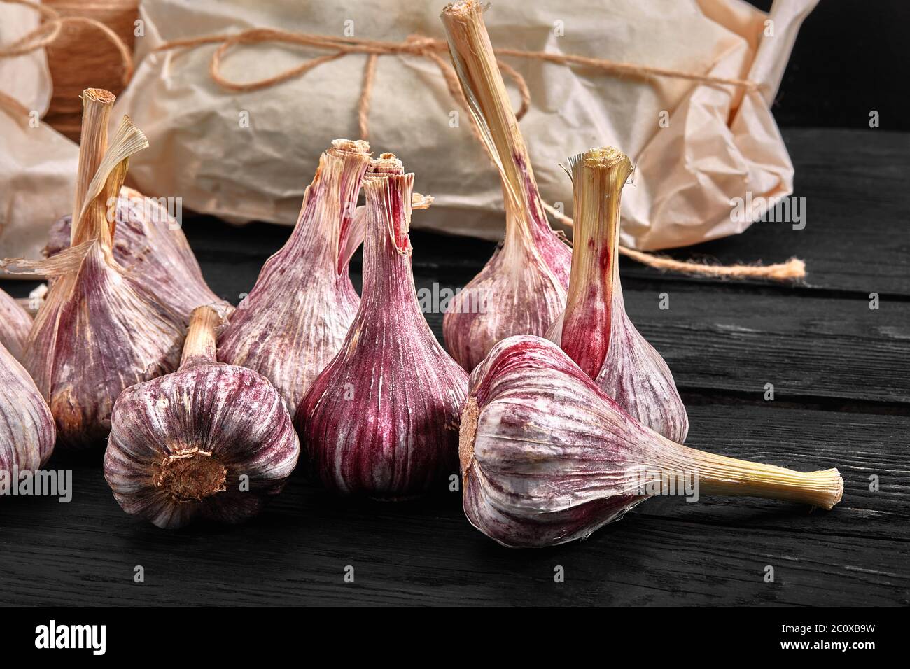 The heads of red garlic on a dark background, ecological packaging ...