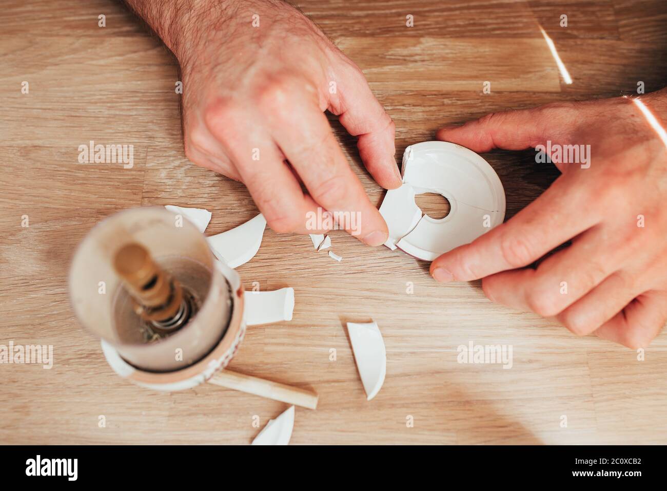 An archaeologist glues pieces of broken ceramics into an entire object ...