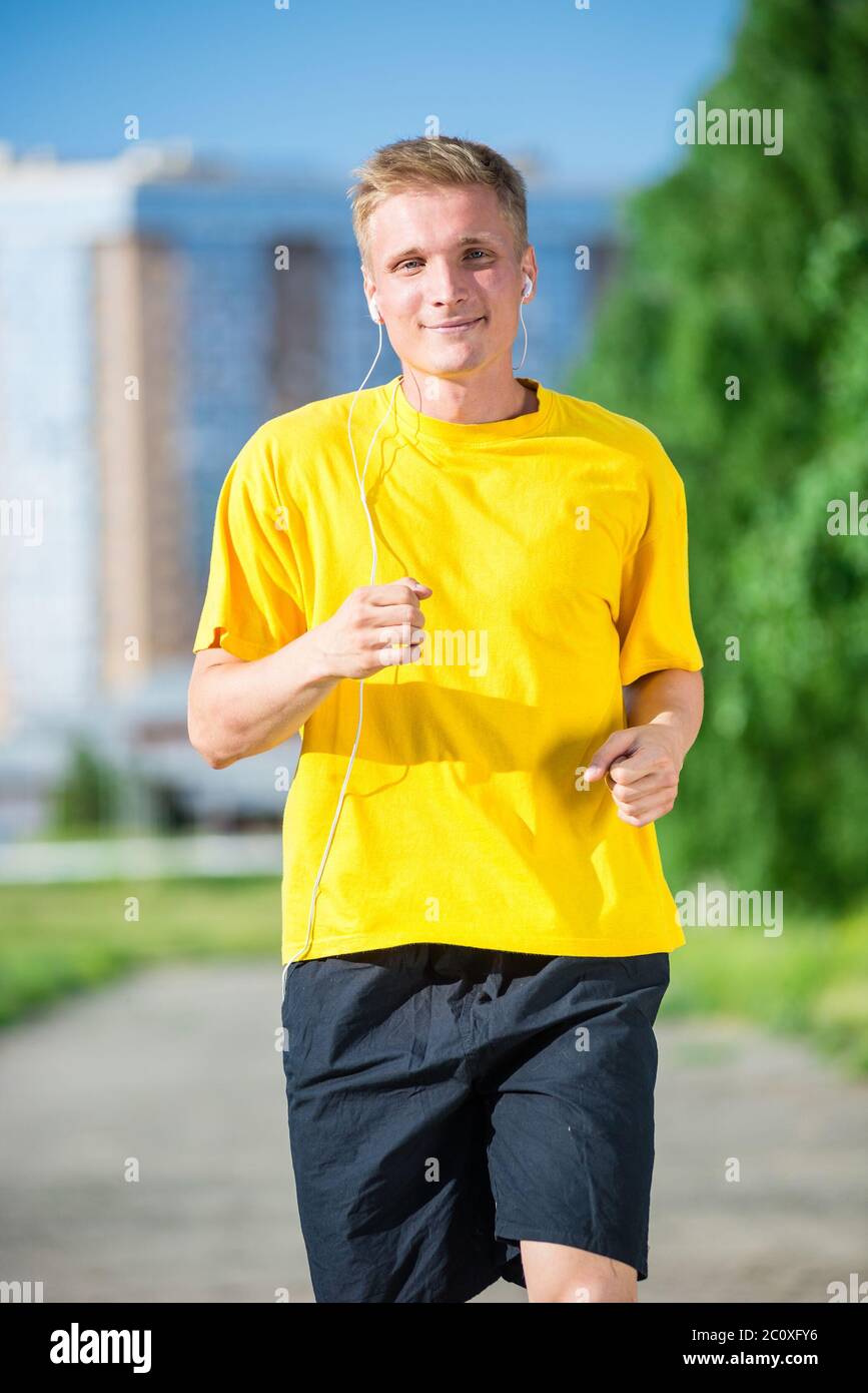 Sporty man jogging in city street park. Outdoor fitness Stock Photo - Alamy