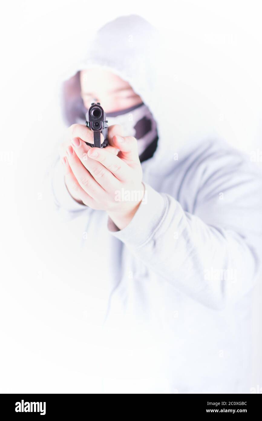 The man in the hood goes with gun in hand Stock Photo - Alamy