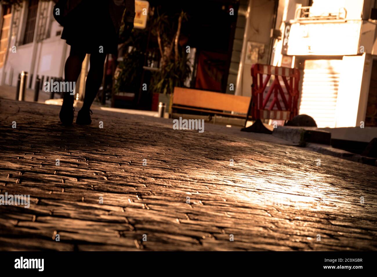 low angle view of an old style cobblestone street with a silhouette of ...
