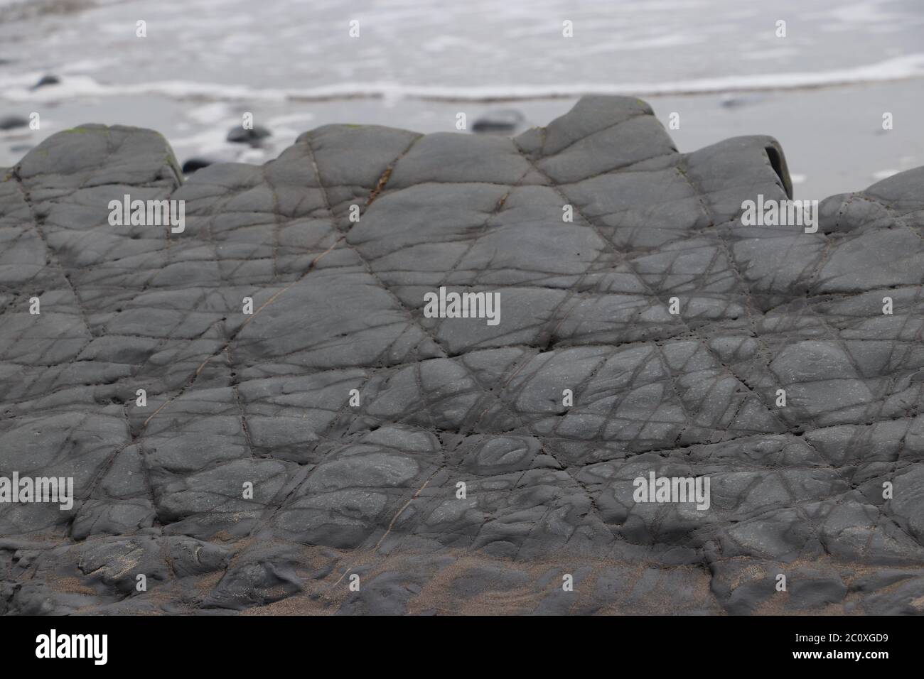 Jagged triangular rock face with geometric patterns Stock Photo - Alamy