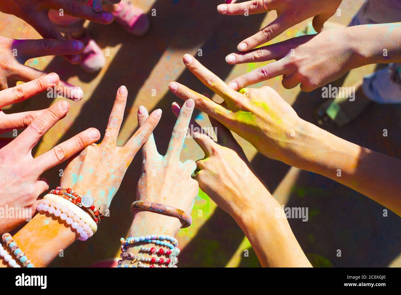 Friends putting their hands together in a sign of unity and teamwork ...