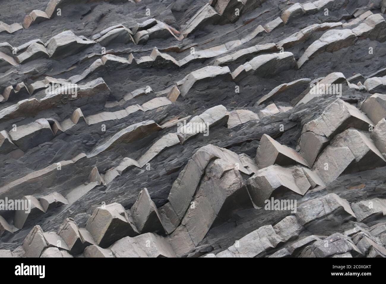 Jagged triangular rock face with geometric patterns Stock Photo - Alamy