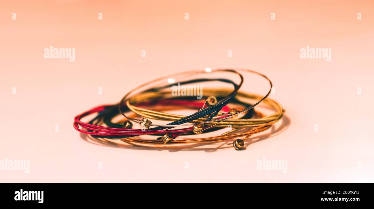 colorful custom made guitar strings on the cream color platform ...