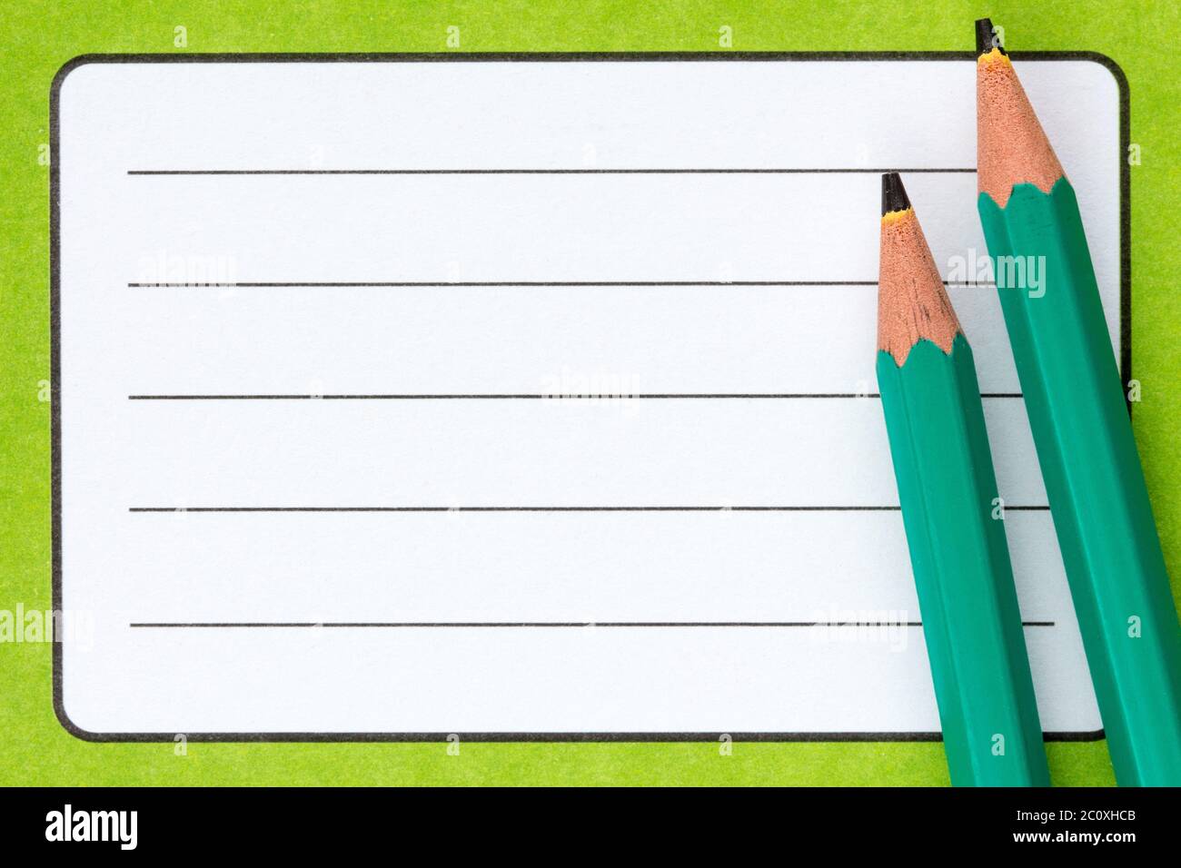 Exercise book name label and pencils Stock Photo - Alamy