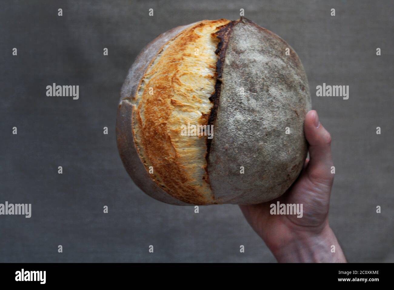 Baker man holding white sourdough bread. Homemade bread food ...