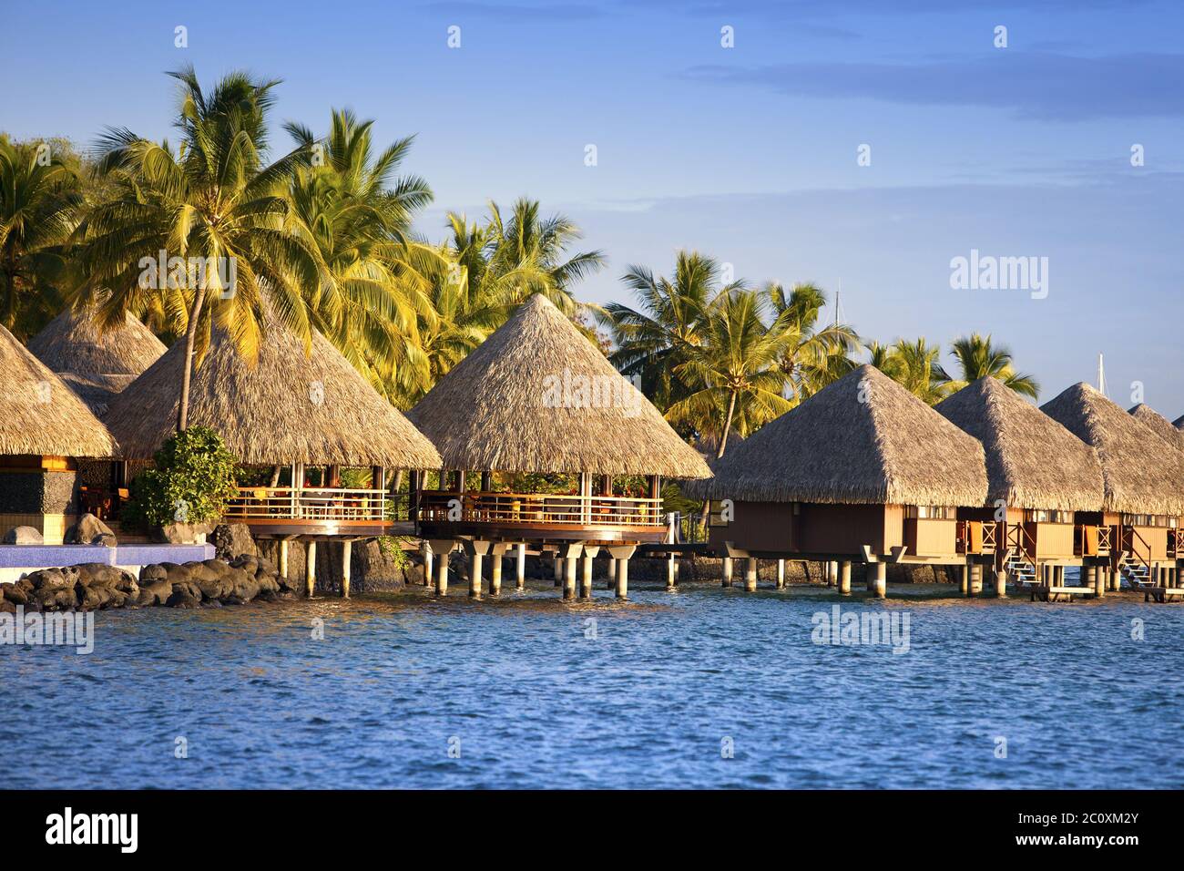 seacoast with palm trees and small houses on water Stock Photo - Alamy