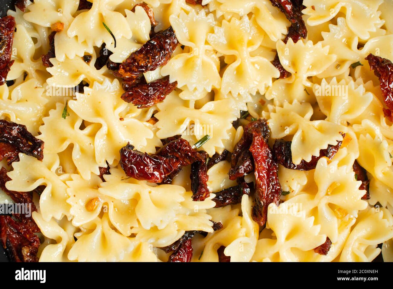 Pan-fried pasta with sun-dried tomatoes and garlic. Stages of cooking ...