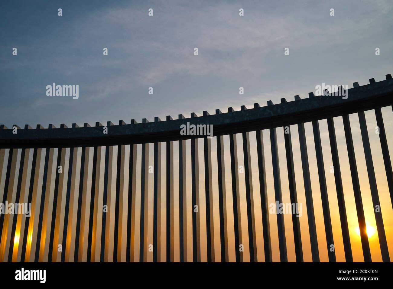 High fence at sunrise border concept Stock Photo - Alamy