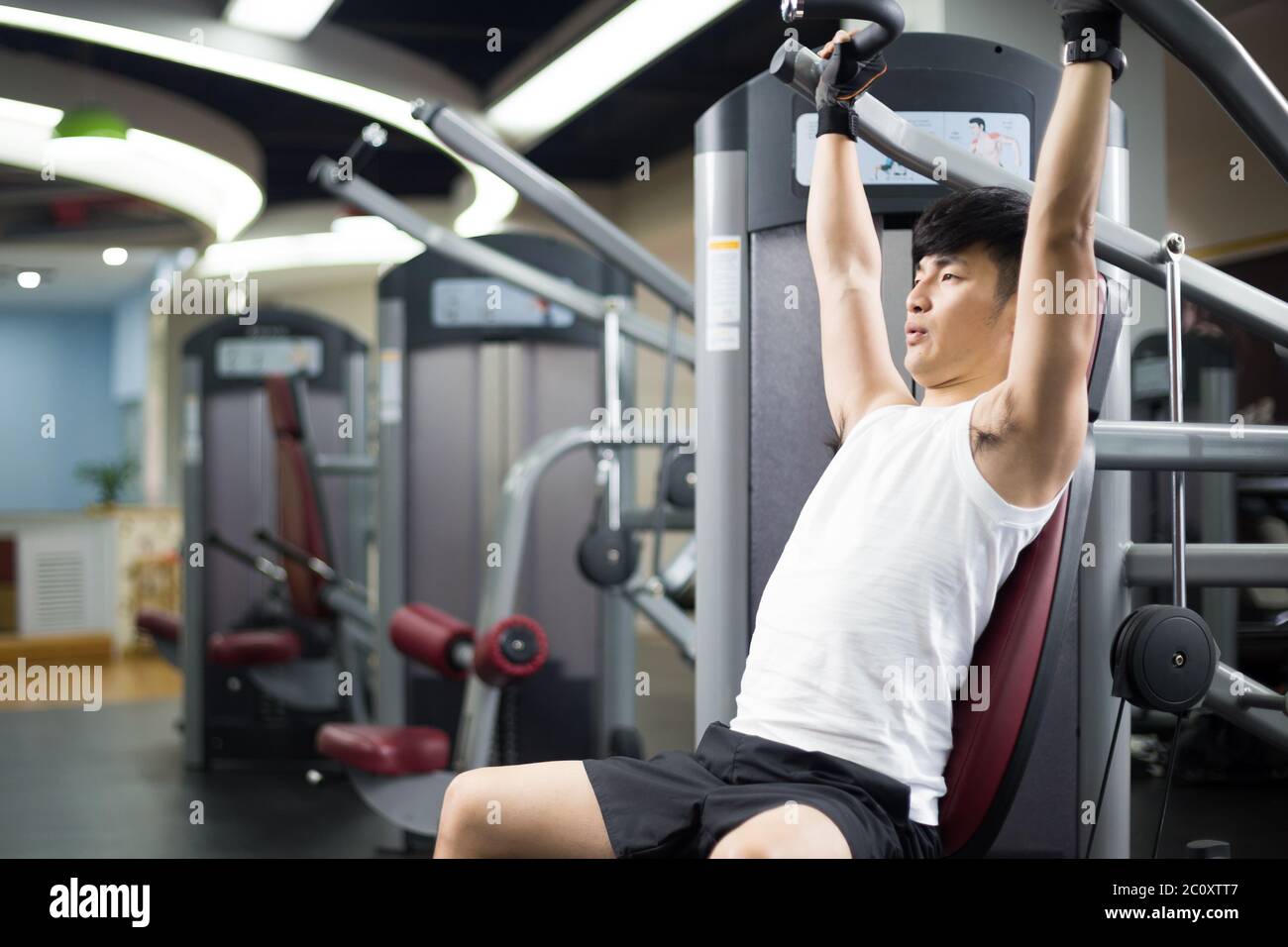 young handsome man works out in modern gym Stock Photo - Alamy