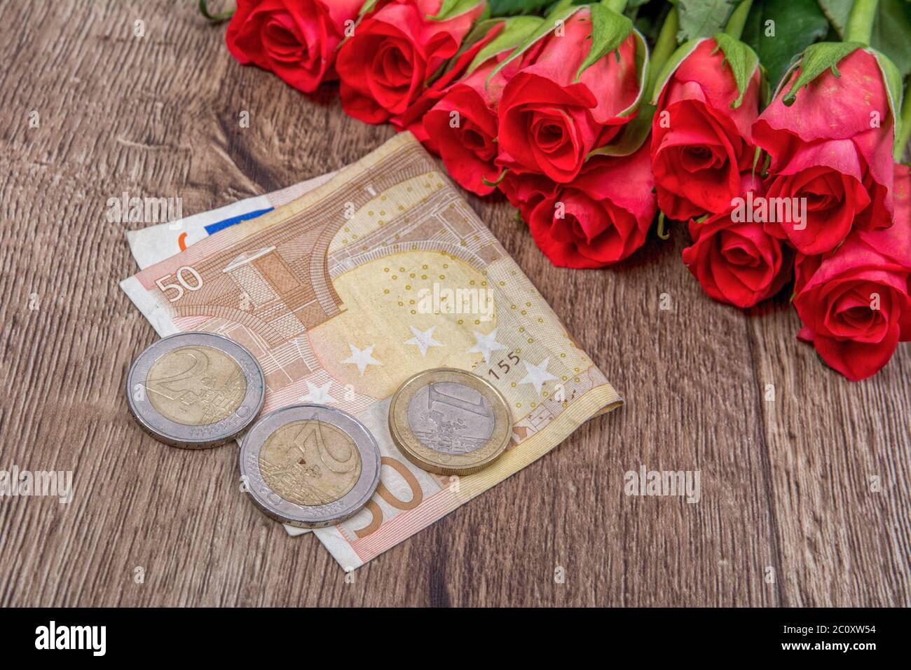 Euro moneys and roses on a wooden background Stock Photo - Alamy