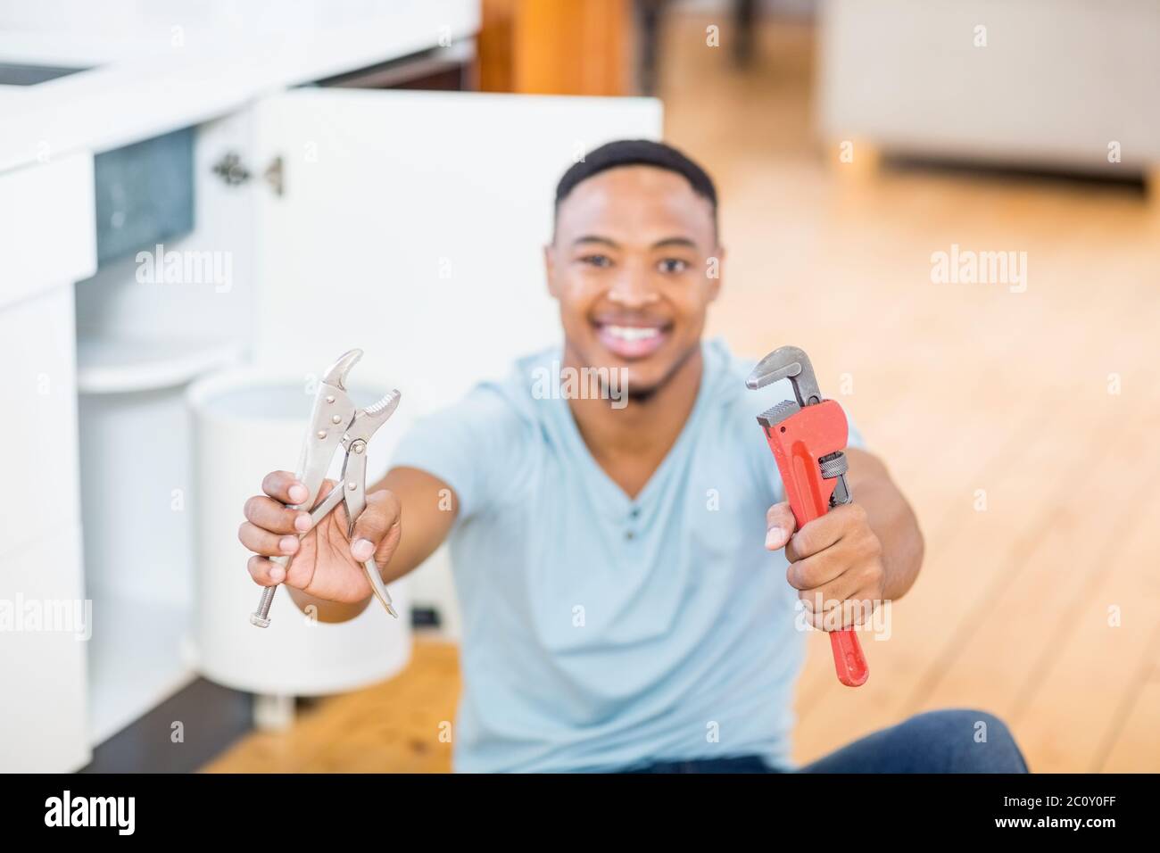 Man showing a wrench while working with a set of tools Stock Photo - Alamy