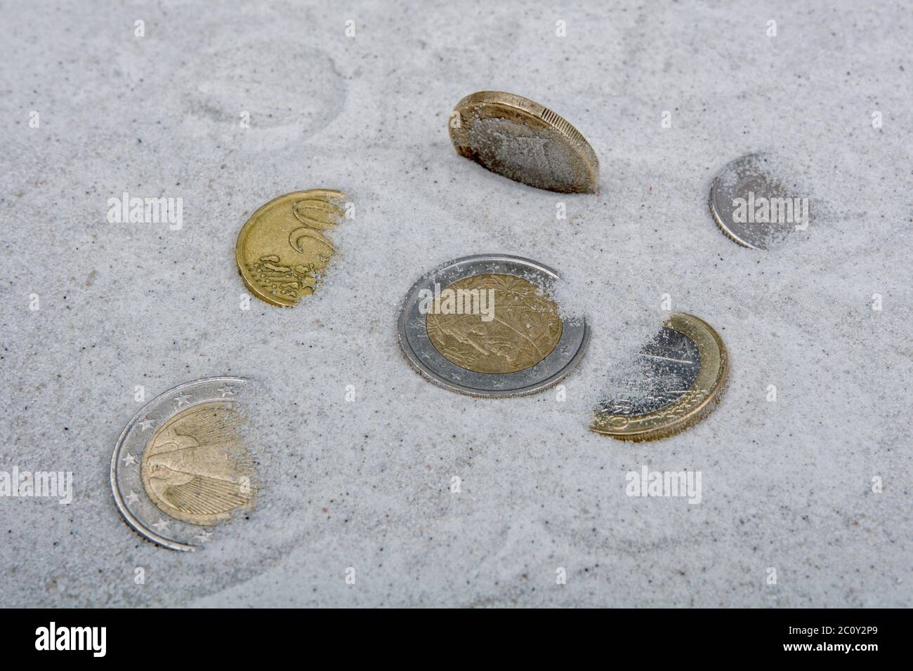 Coins in a sand background Stock Photo - Alamy