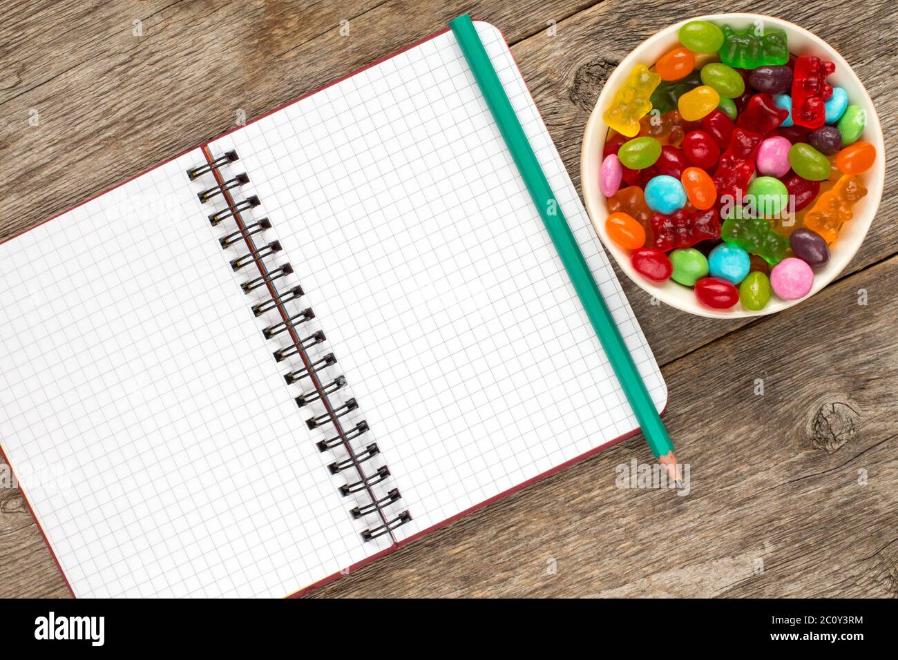 Spiral notebook and bowl with candies Stock Photo - Alamy