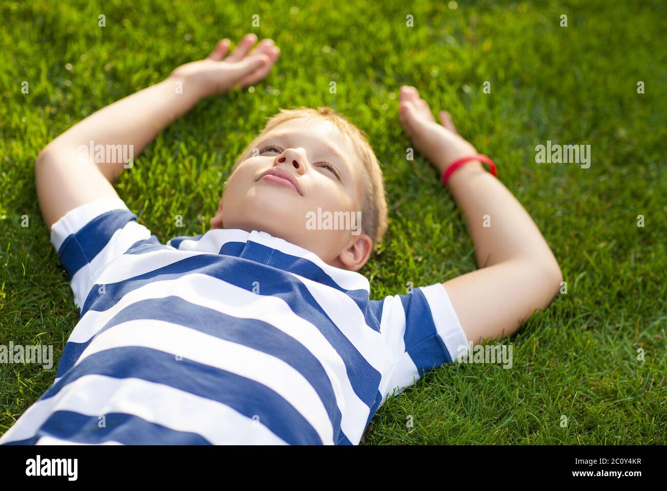 Little boy lay down on the grass Stock Photo - Alamy