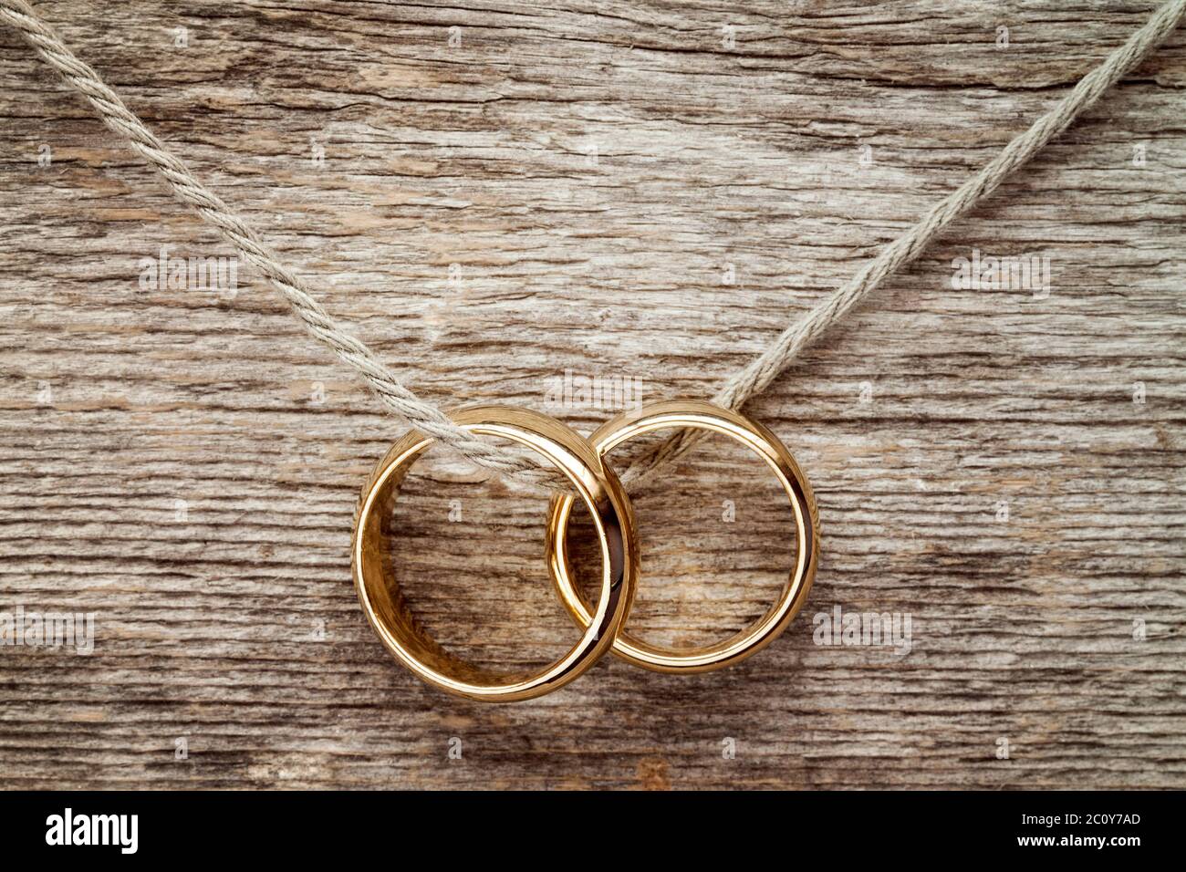 Wedding rings hanging on rope Stock Photo - Alamy