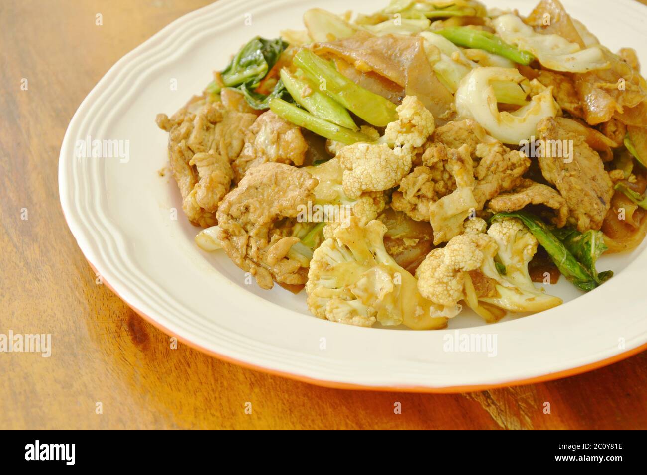 fried large rice noodles with pork and vegetable in black soy sauce on ...