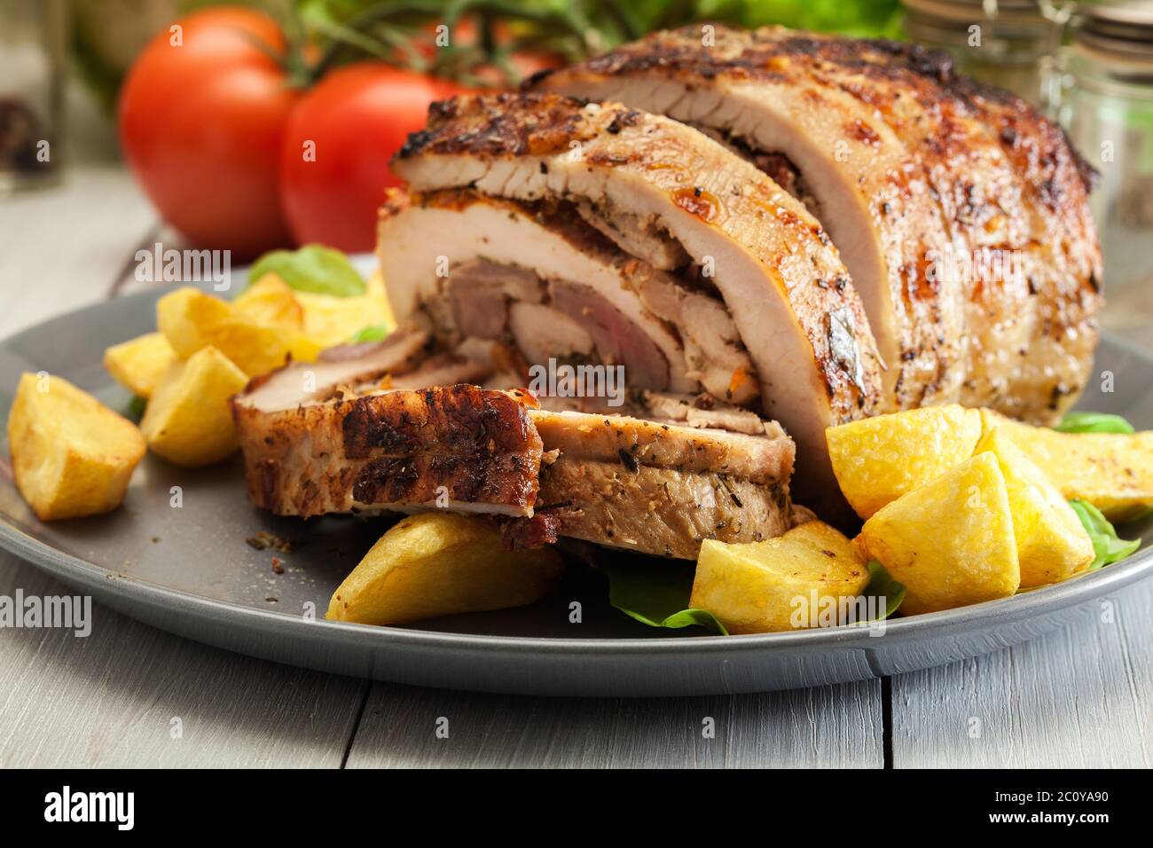 Roasted pork roll stuffed with other meat and dried tomatoes served ...