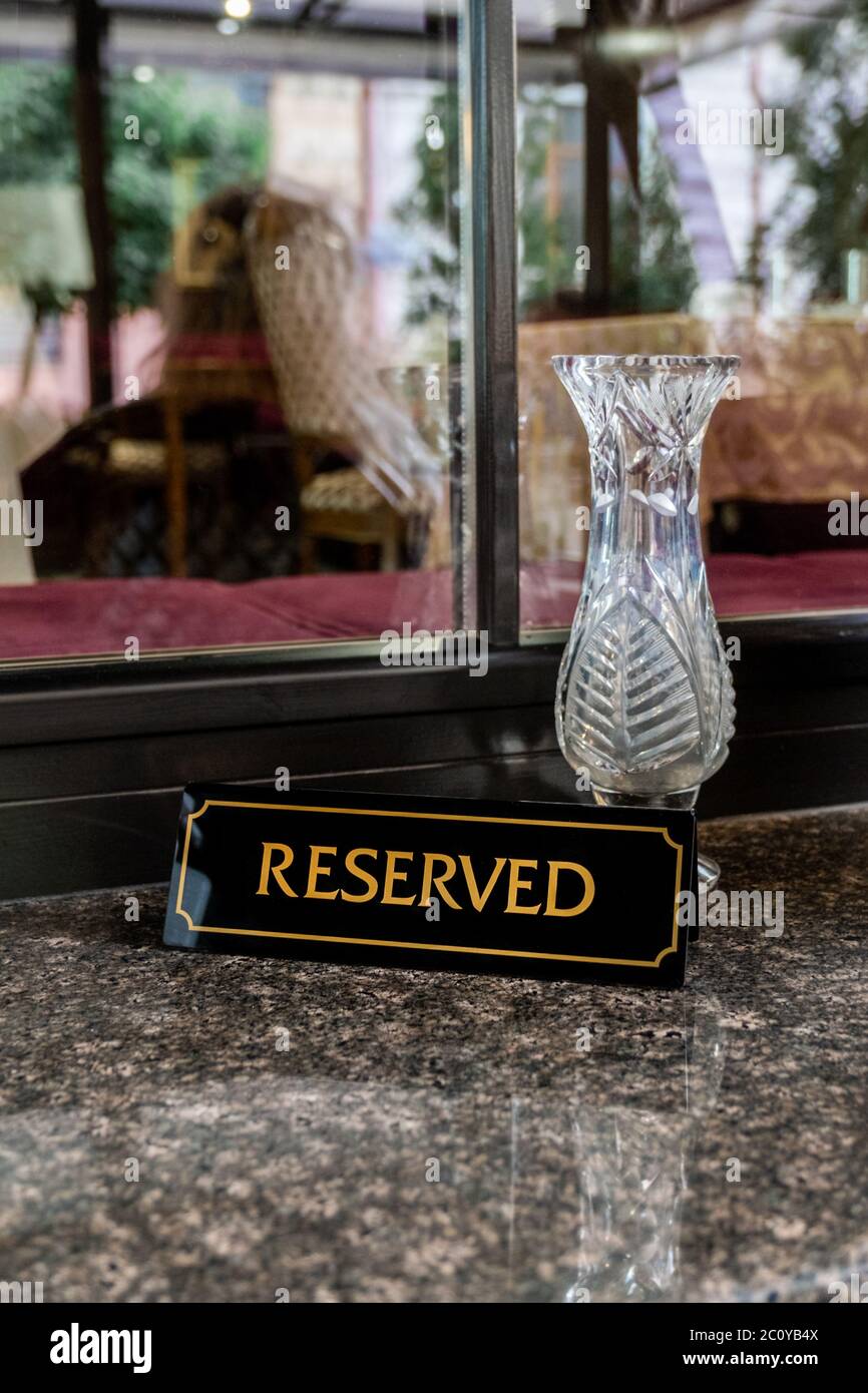 A tag of reservation placed on table. Reserved logo in a restaurant or ...