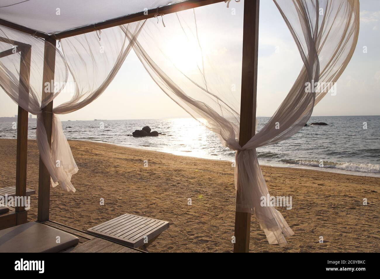 View of a beach in sunset through the curtains of a beach bed Stock ...