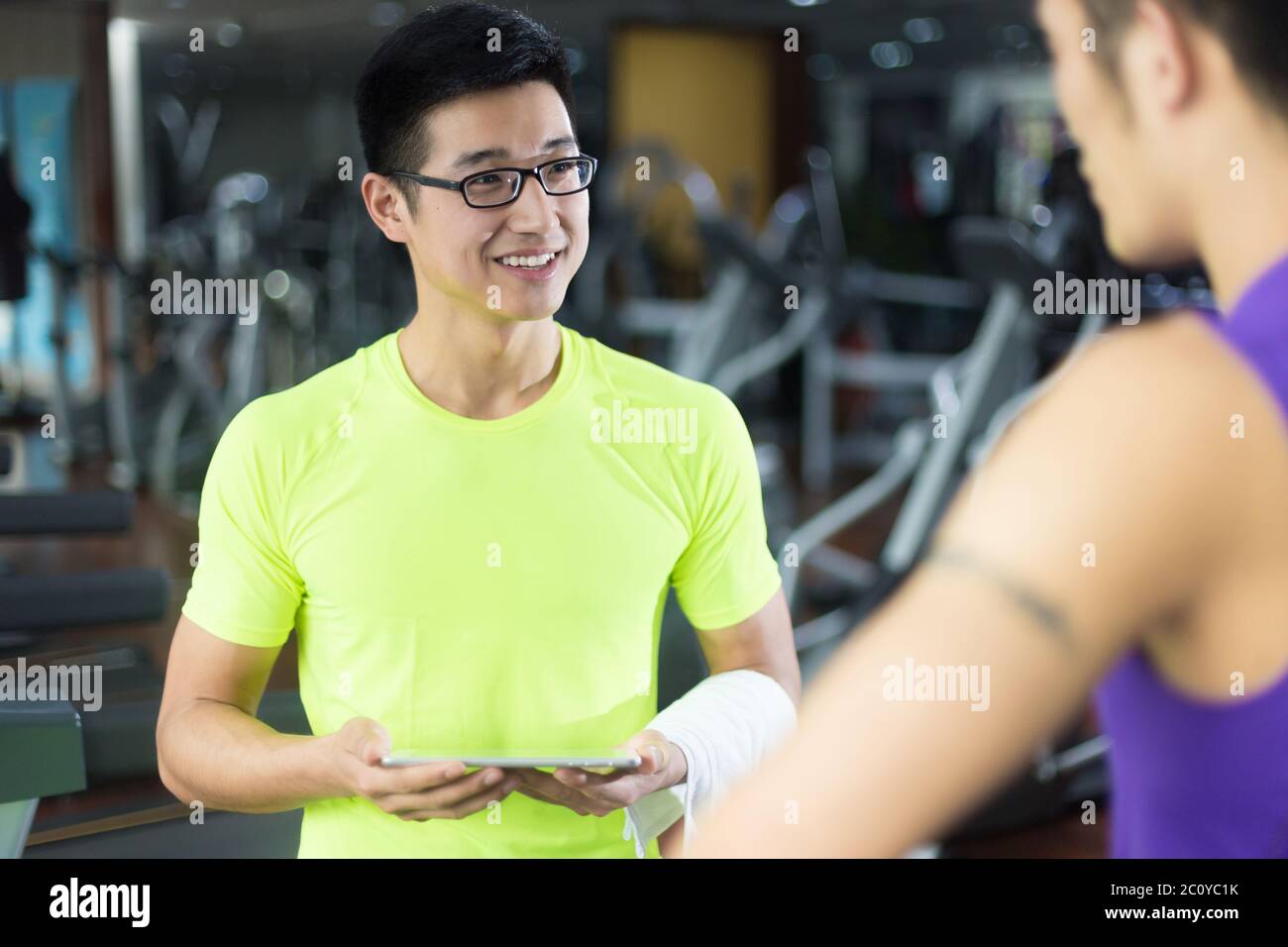 young asian people talking by tablet in modern gym Stock Photo - Alamy