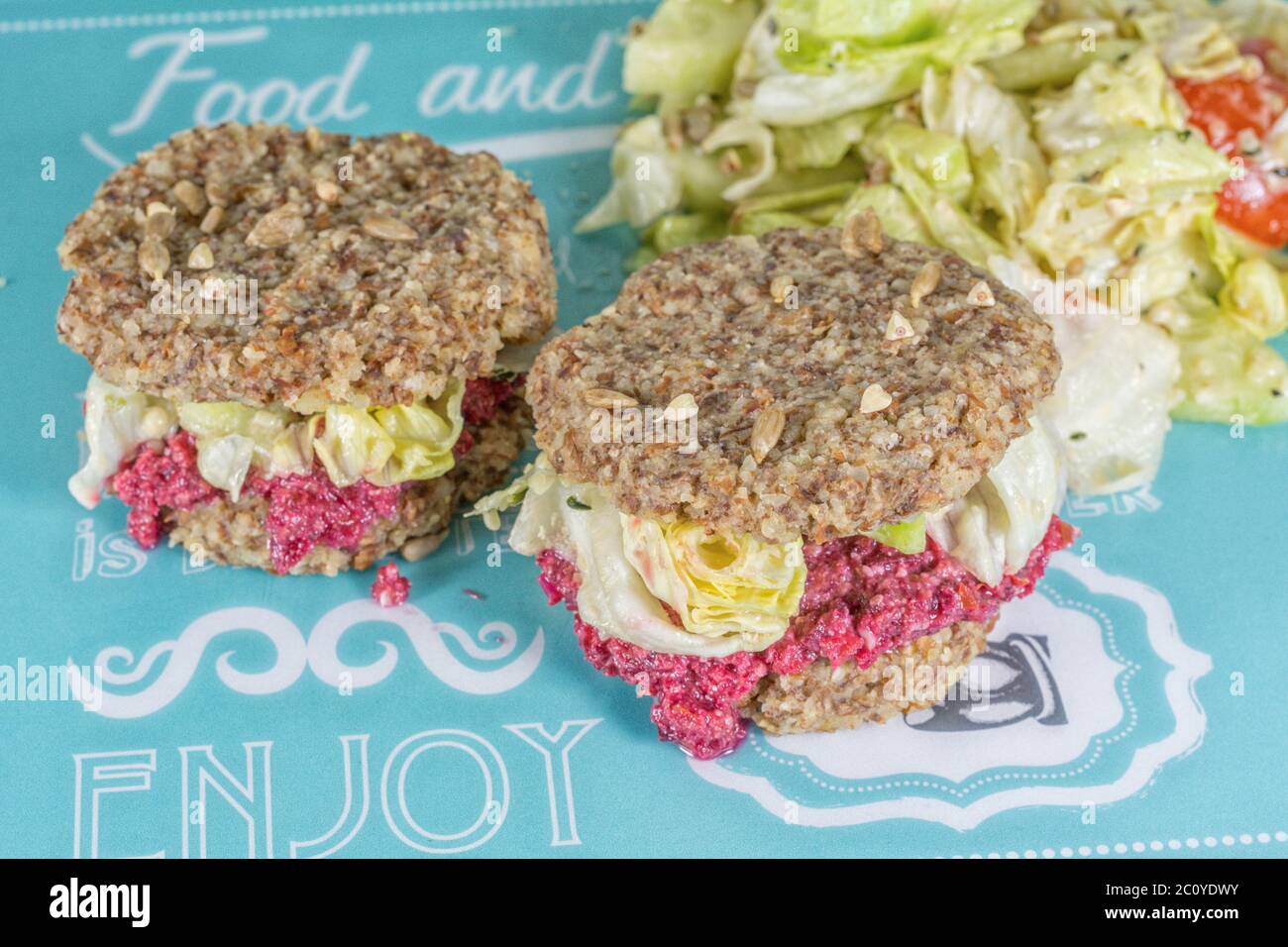 Raw burgers and salad on a blue background Stock Photo - Alamy
