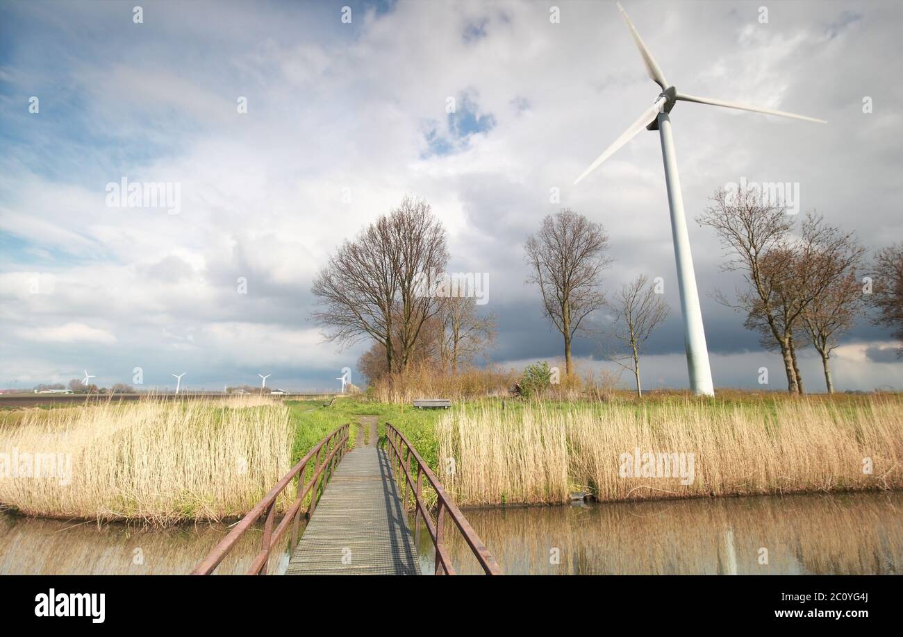bridge via river and wind turbine over sky Stock Photo - Alamy