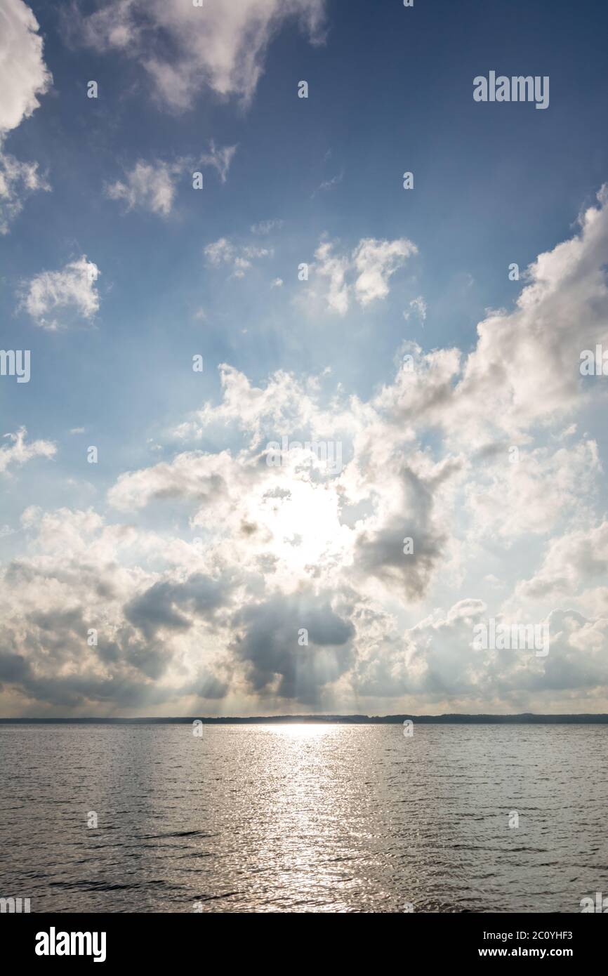 Sun shining dramatically through the clouds over the ocean Stock Photo ...
