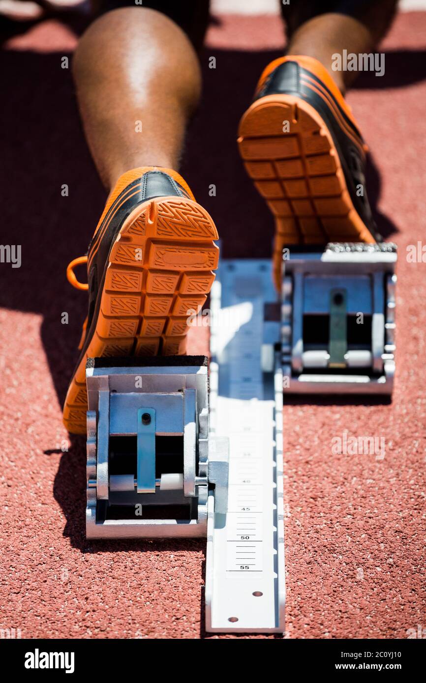 Feet of an athlete on a starting block about to run Stock Photo - Alamy