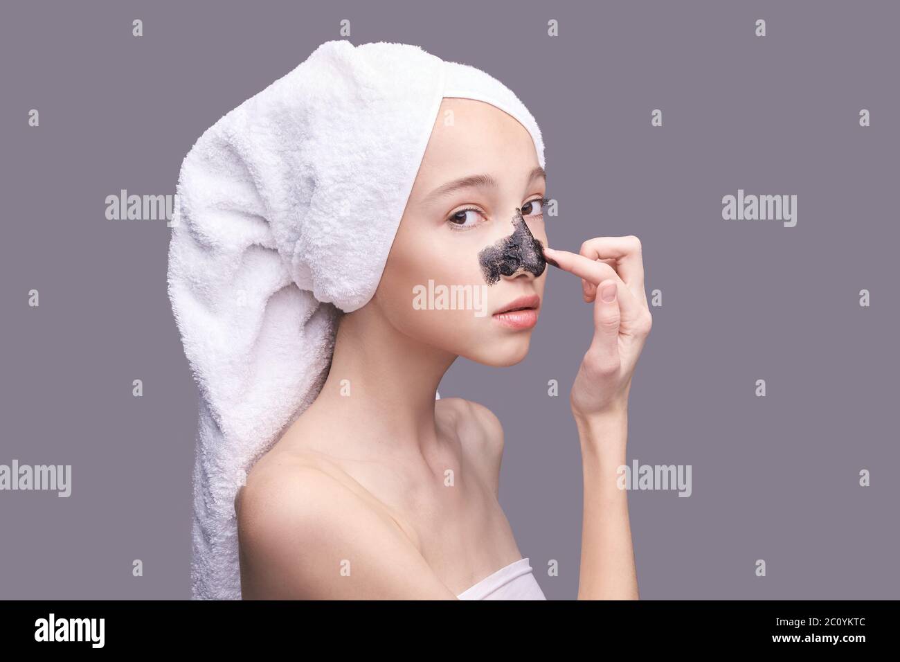 Young girl applying black face mask Stock Photo - Alamy