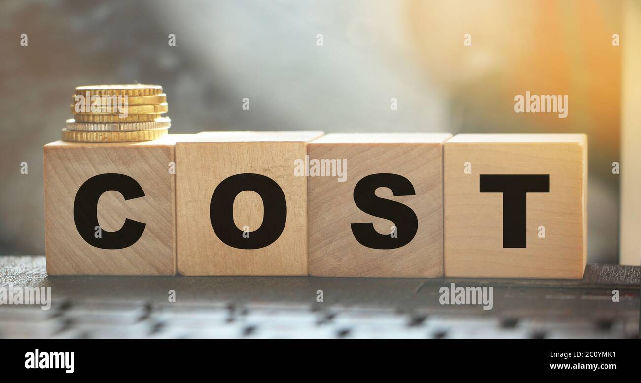 Cost word on cubic wooden blocks with alphabet put on computer keyboard ...